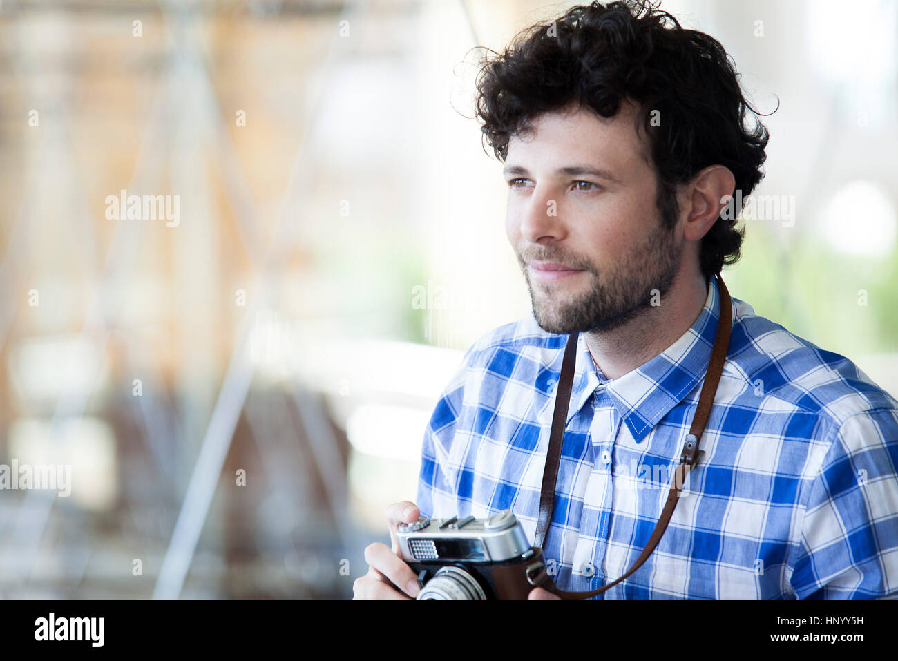 Man holding camera and smiling Stock Photo - Alamy