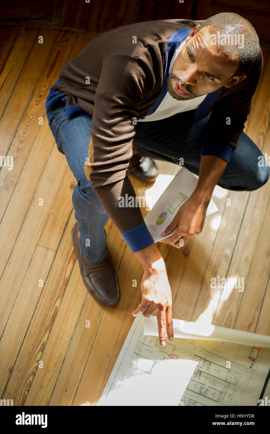 Architect looking at blueprint Stock Photo - Alamy