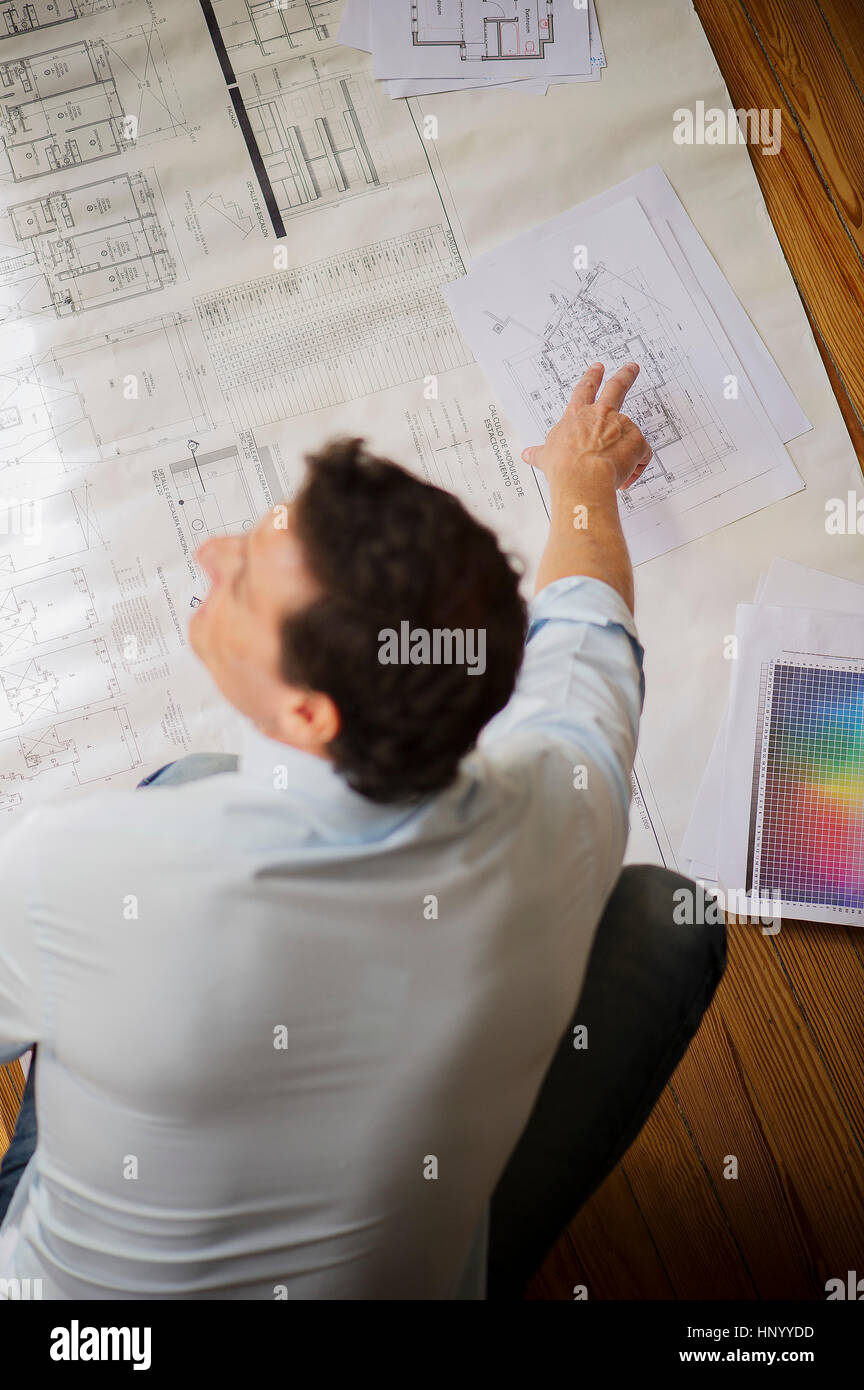 Architect looking at blueprint Stock Photo - Alamy