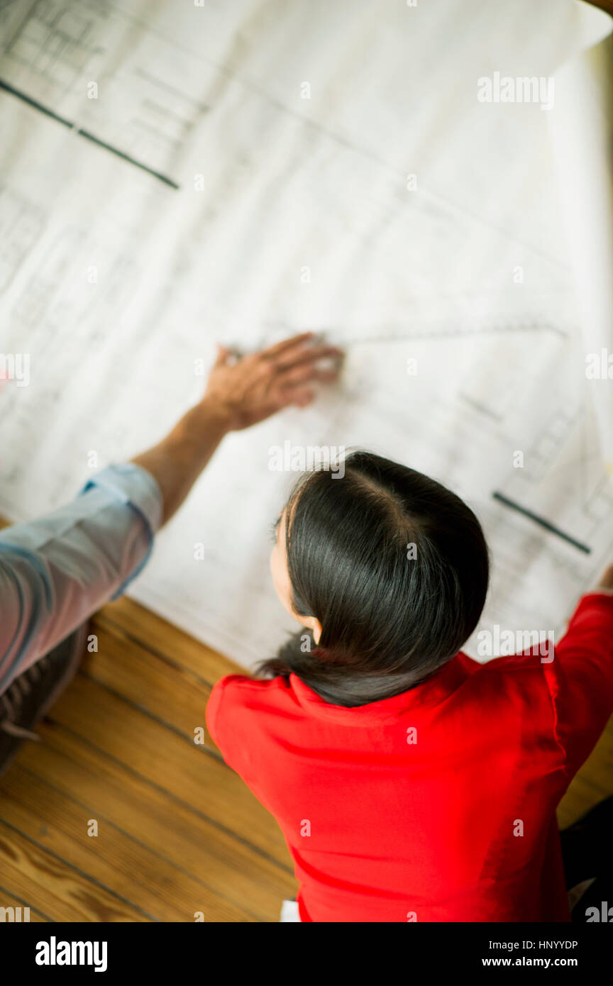 Colleagues looking at blueprint together Stock Photo - Alamy