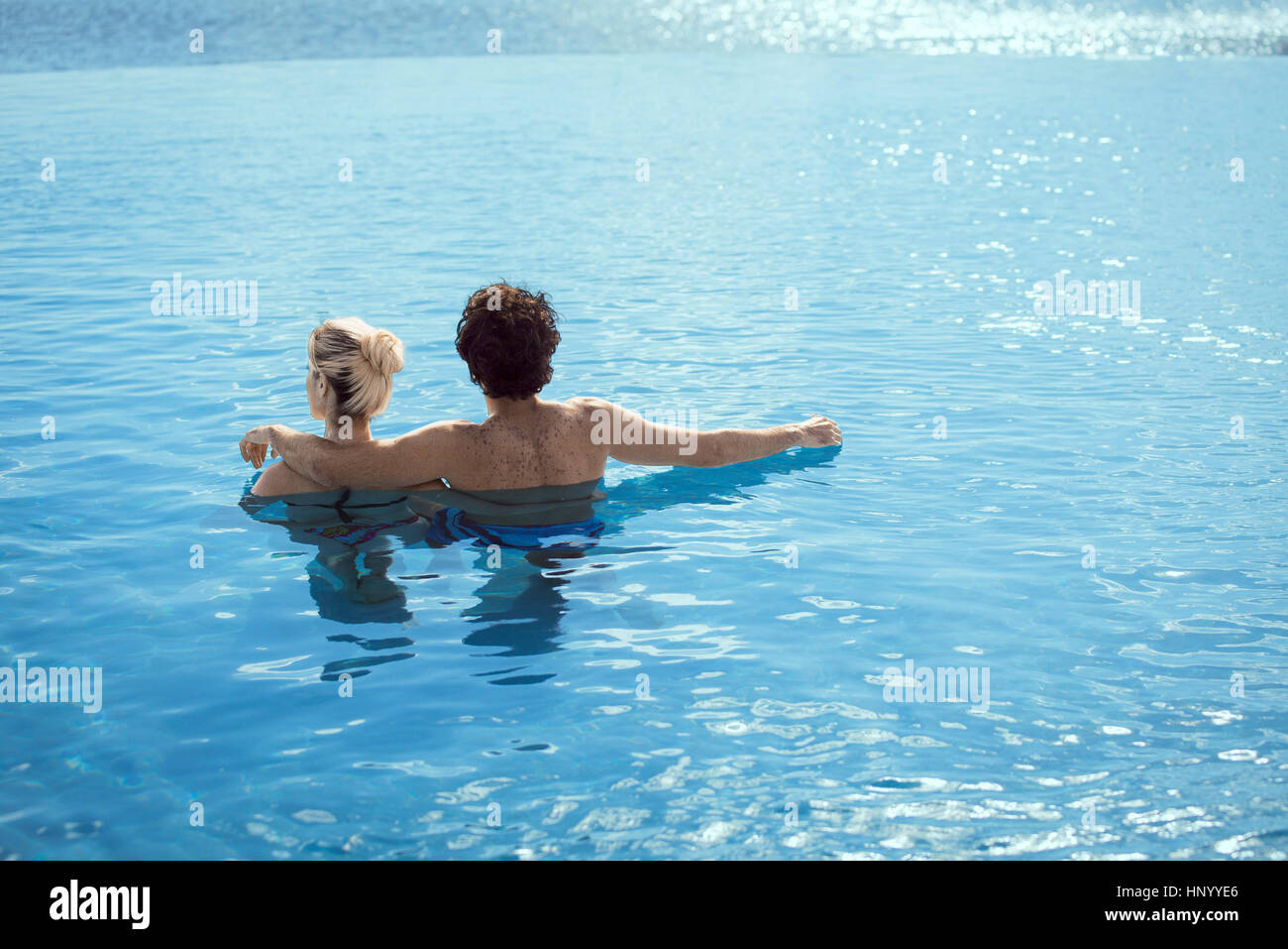 Couple relaxing together in water, rear view Stock Photo - Alamy