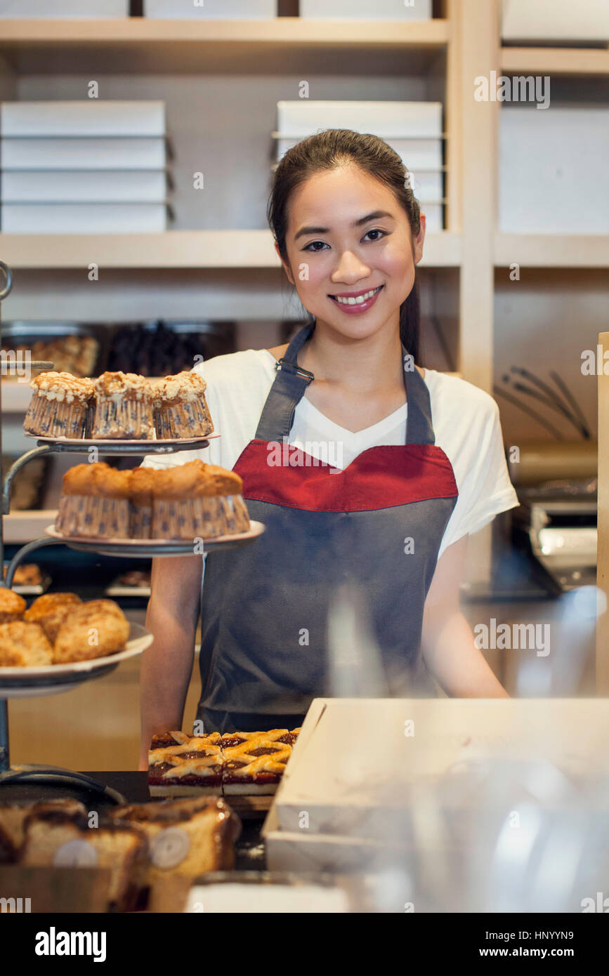 Woman working behind bakery counter, portrait Stock Photo - Alamy