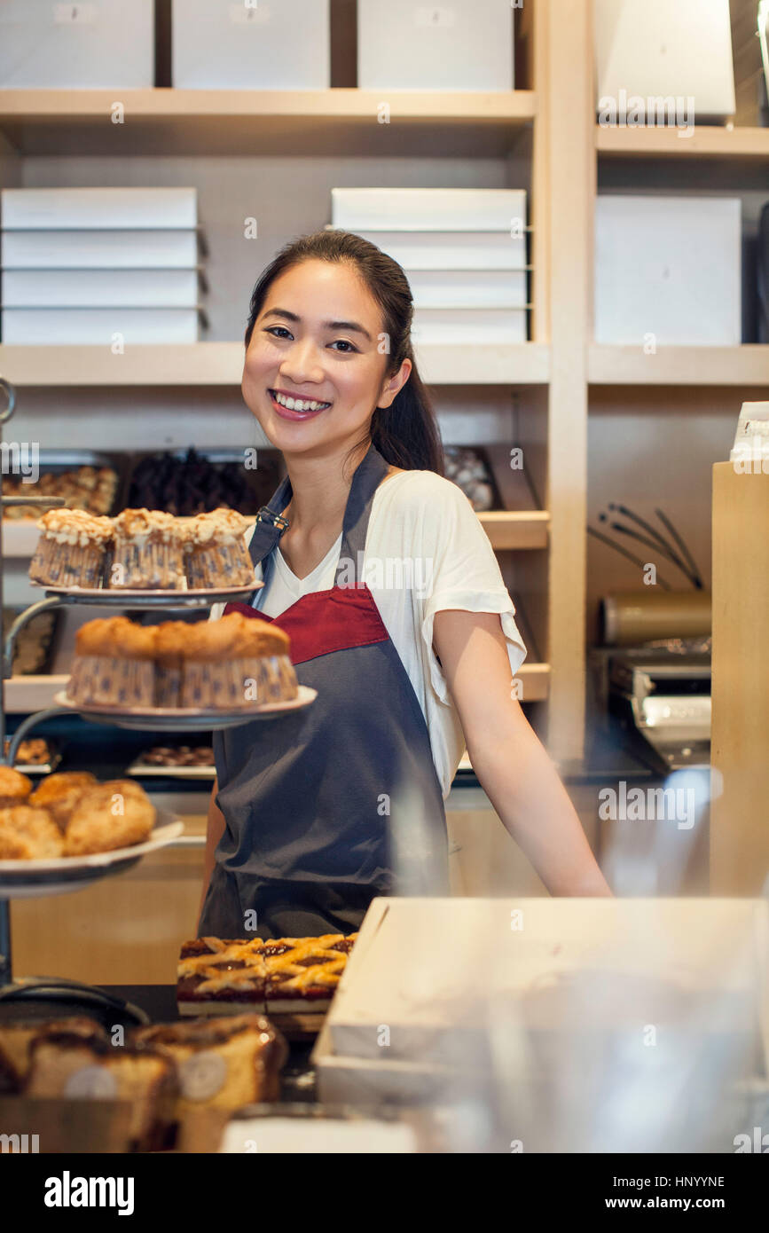 Young woman behind bakery counter, portrait Stock Photo - Alamy
