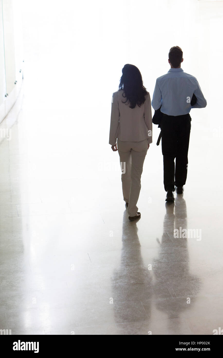 Business colleagues walking together in office corridor Stock Photo - Alamy