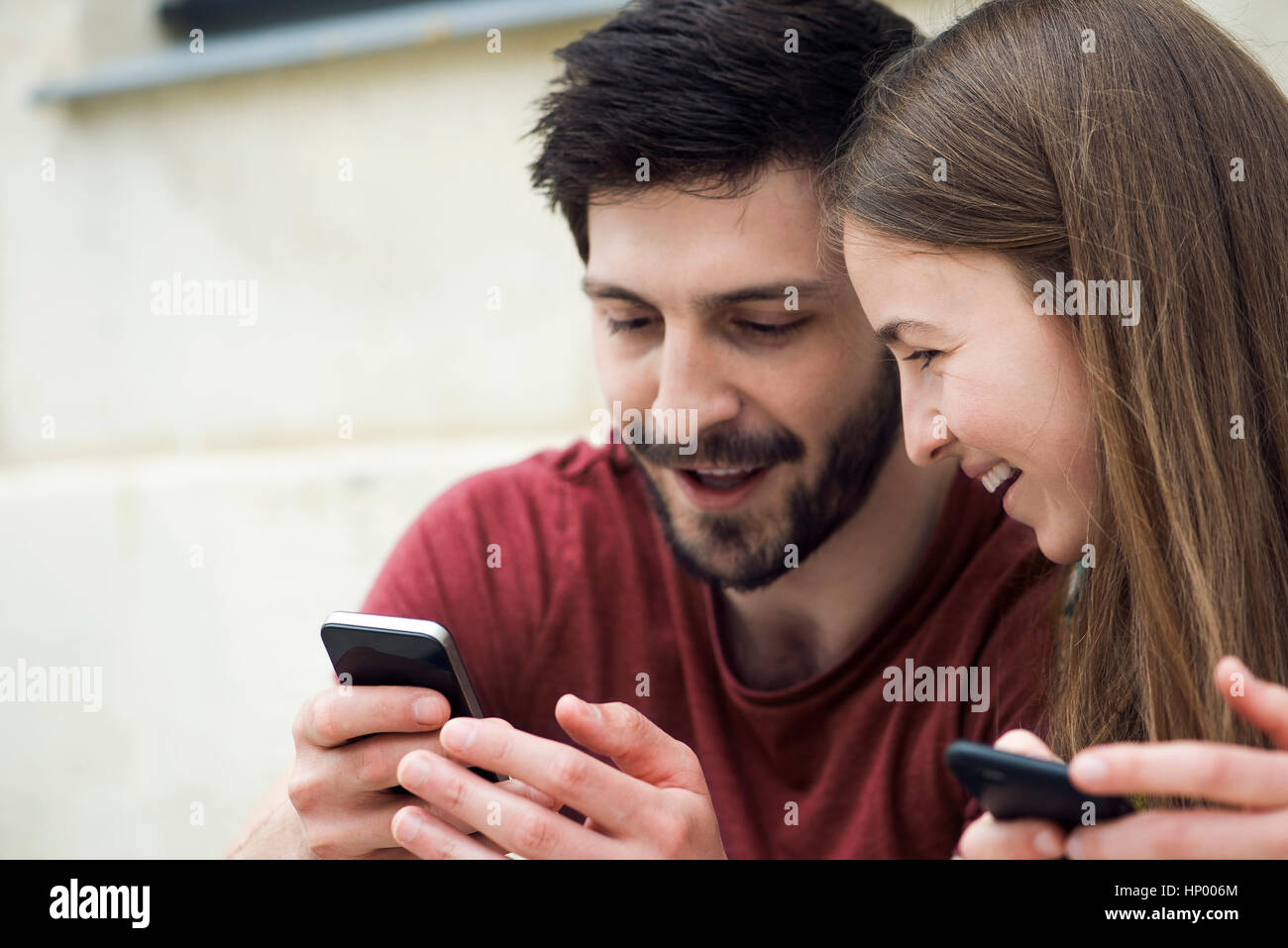 Couple using smartphone together Stock Photo - Alamy
