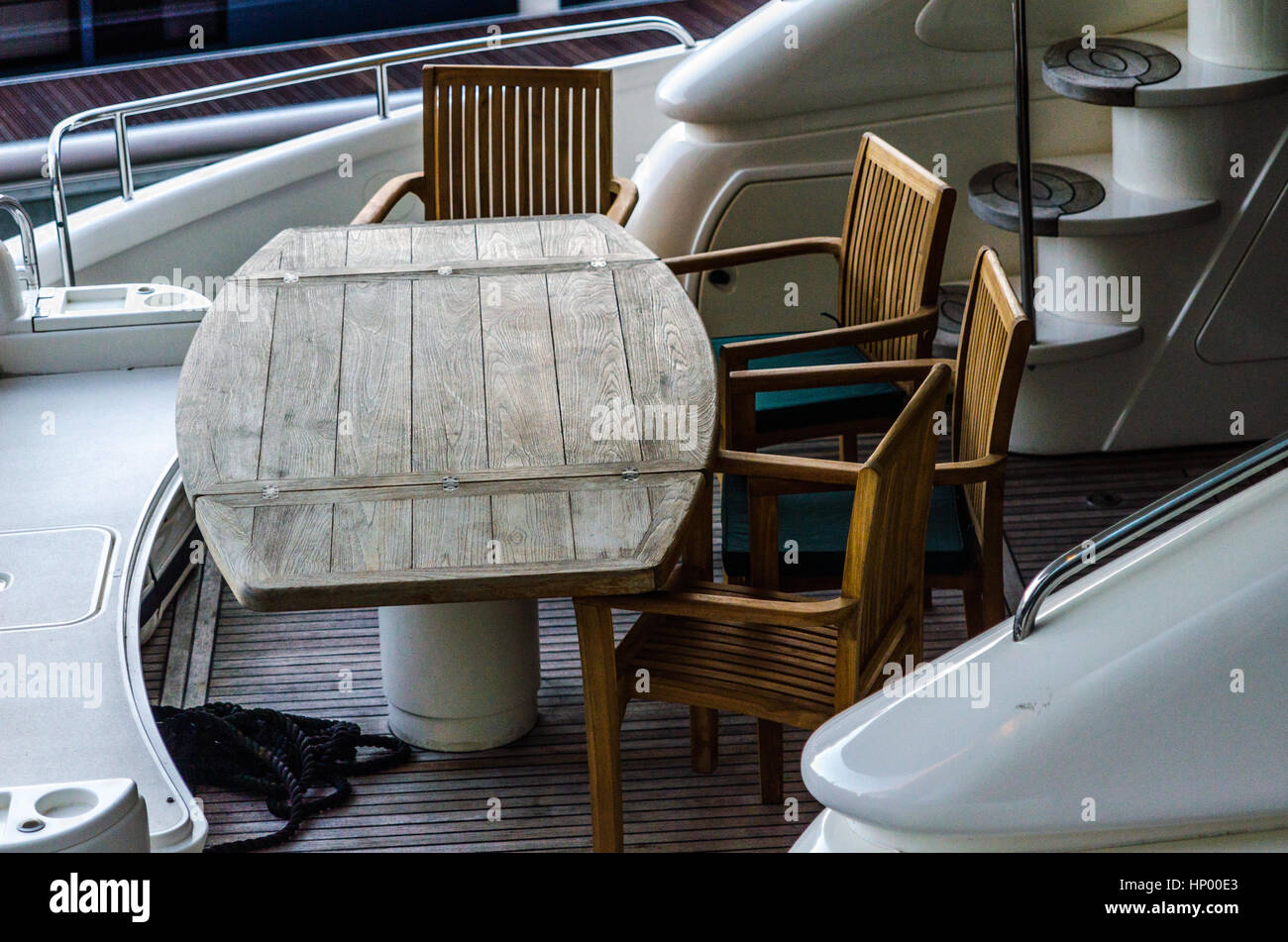 wooden table and chairs at the stern of a large ship anchored in port ...