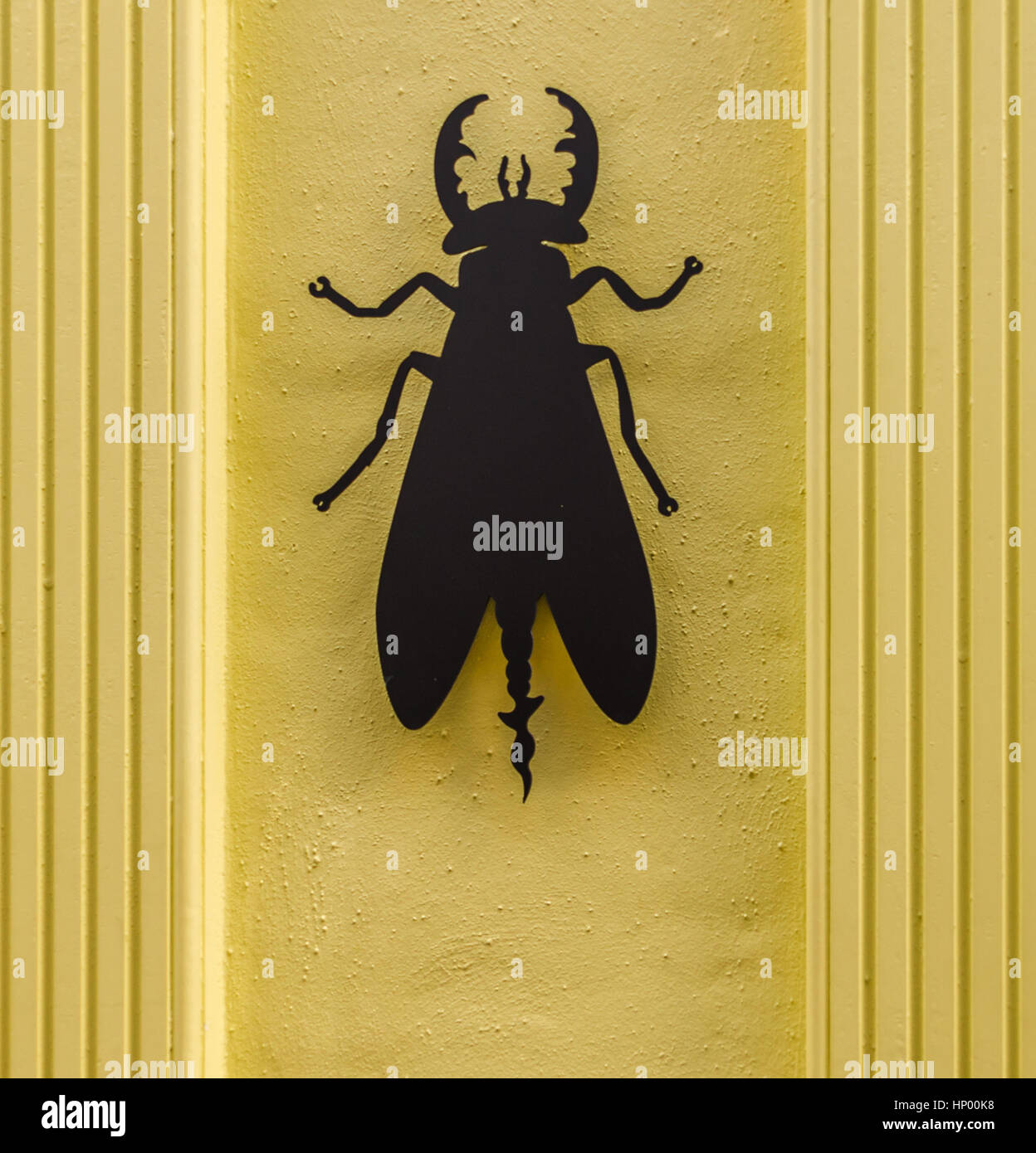 black metal beetle on a stylish yellow facade of the building Stock ...