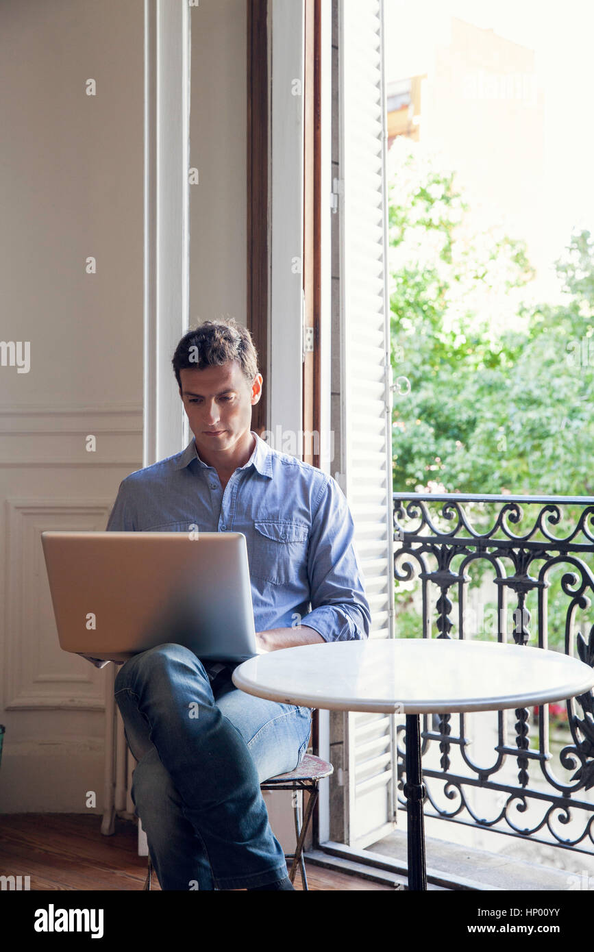 Man working on laptop computer at home Stock Photo - Alamy
