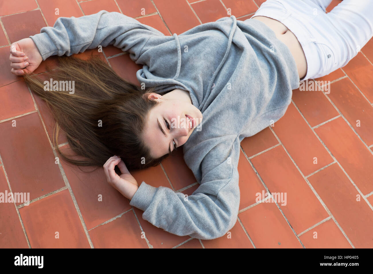 Young woman lying on laid floor. Horizontal shot with natural light ...