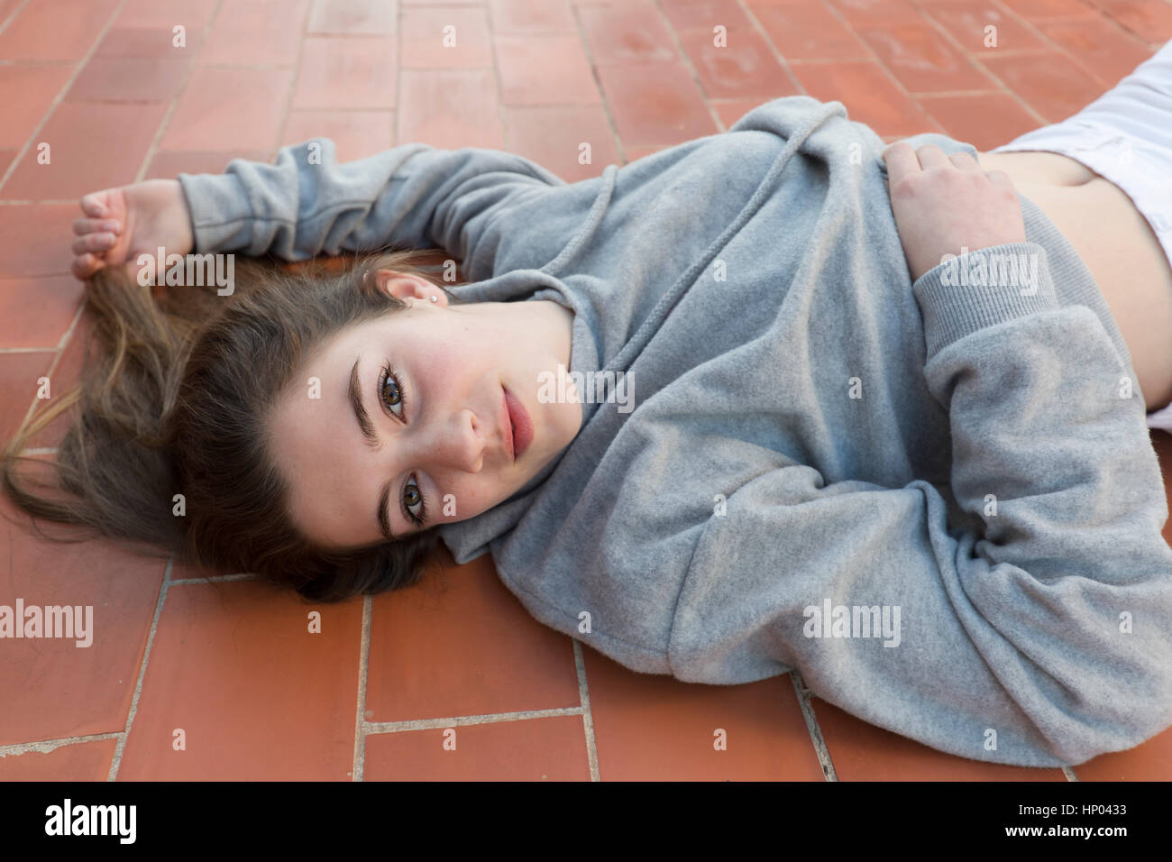 Young woman lying on laid floor. Horizontal shot with natural light ...