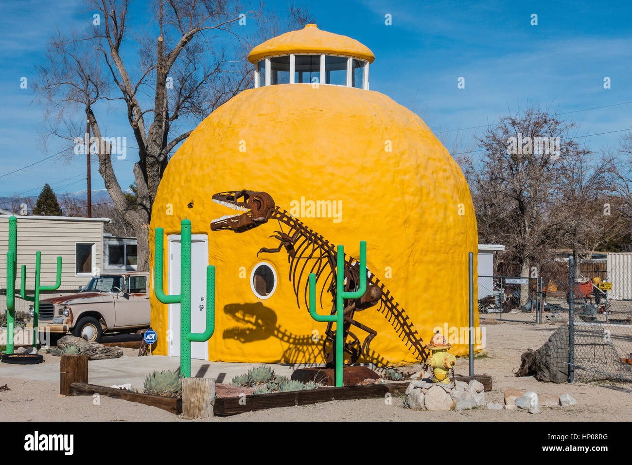 A Yellow Dome structure with green cactus sculptures and a metal ...