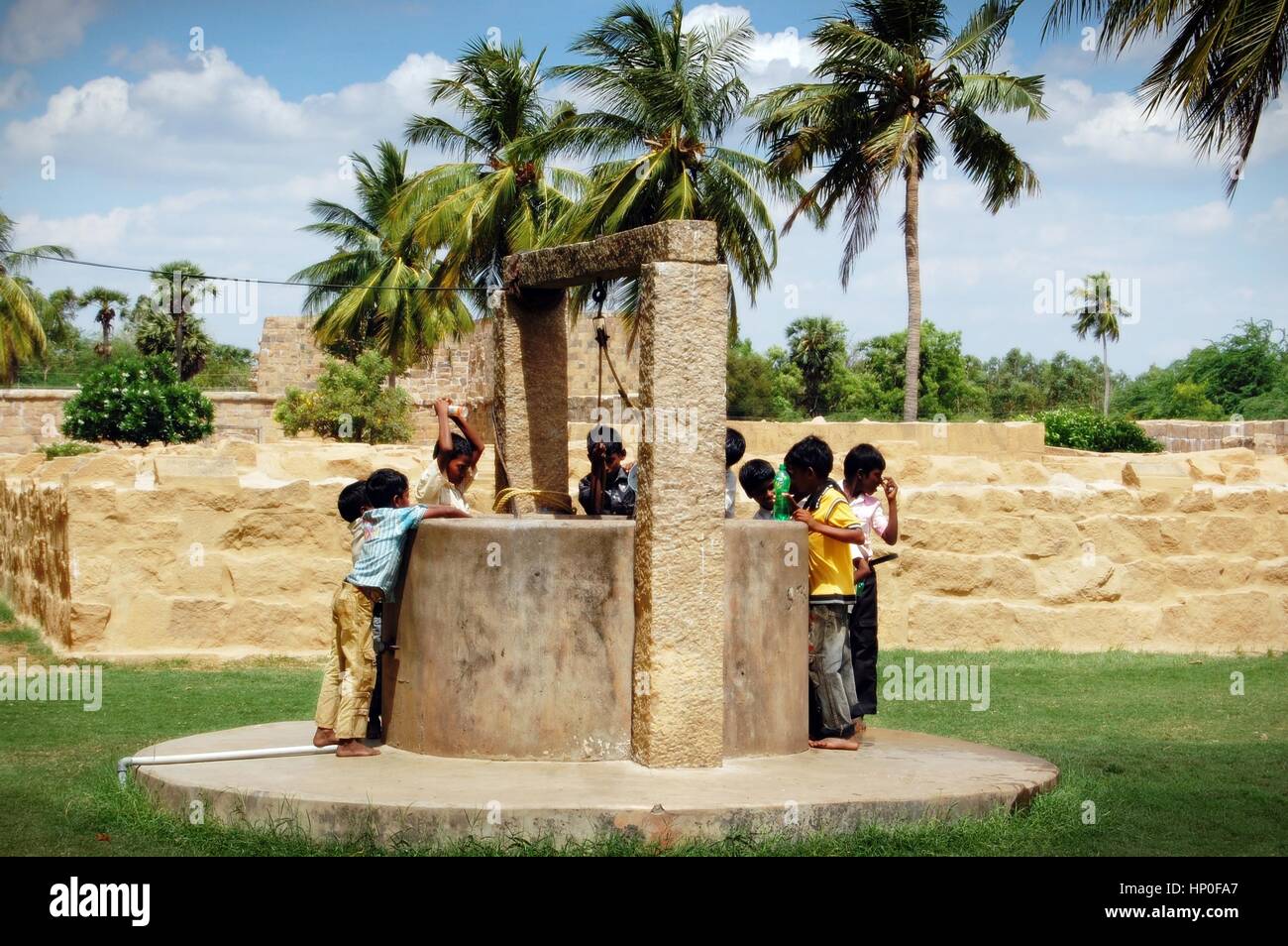 Indian boys gather at the well to draw water on a blazing hot day in ...