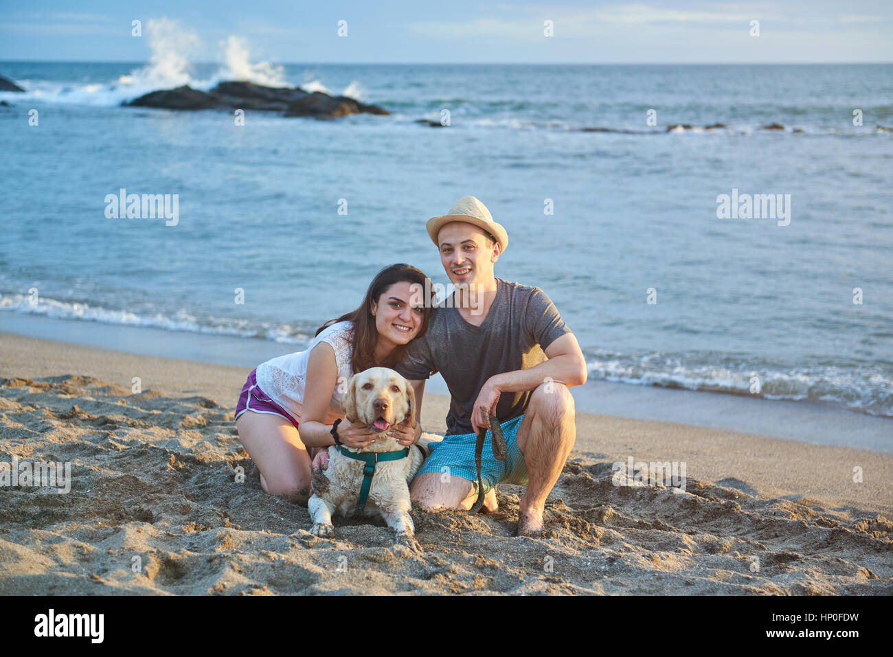 Couple with labrador dog on ocean beach sand sunset Stock Photo - Alamy