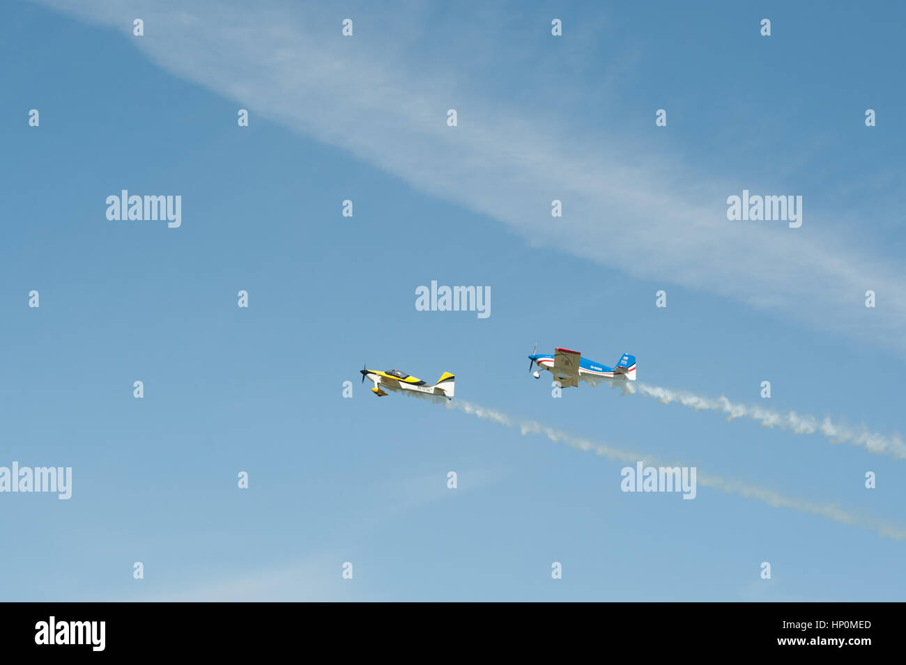 Two single-engine biplane aircraft flying in the sky against a ...