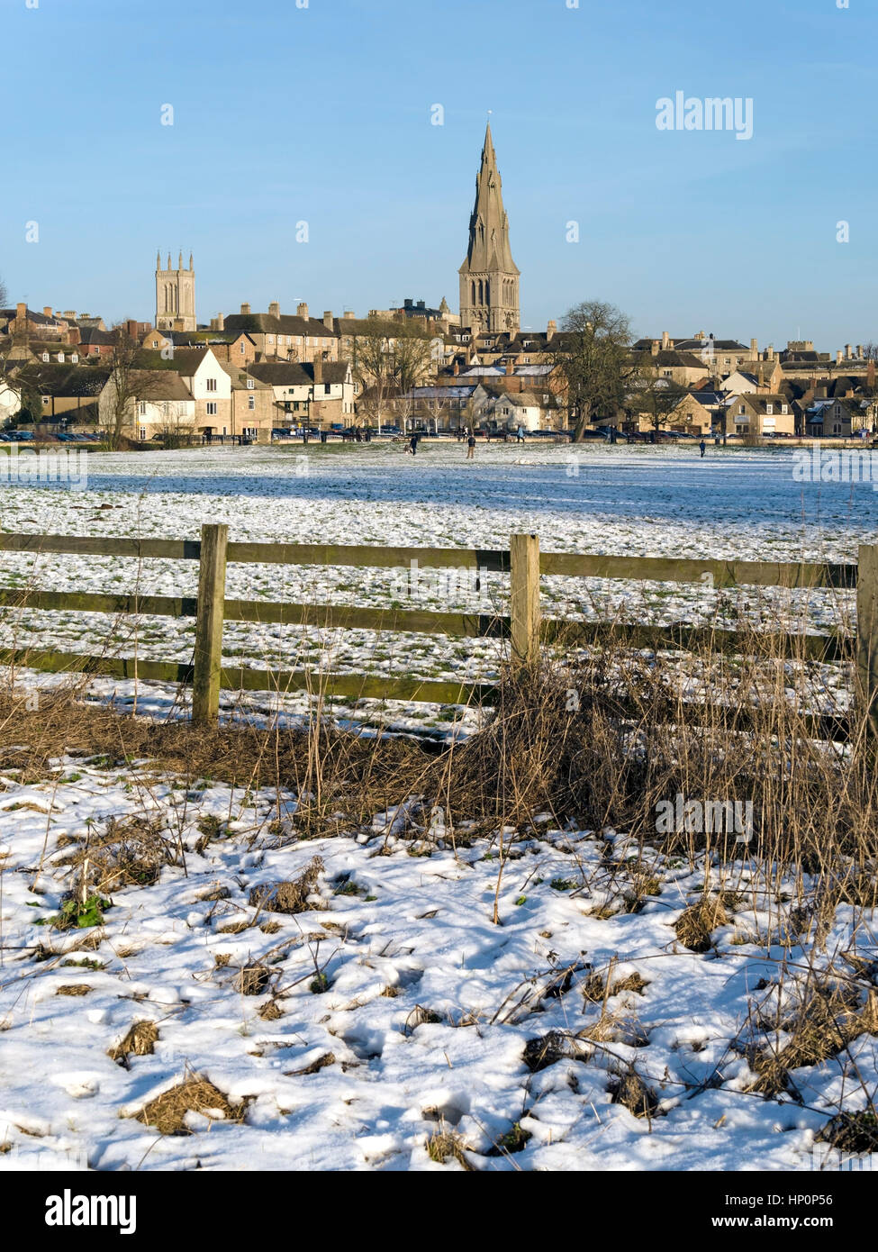 Lincolnshire town of Stamford seen across water meadows in Winter snow ...