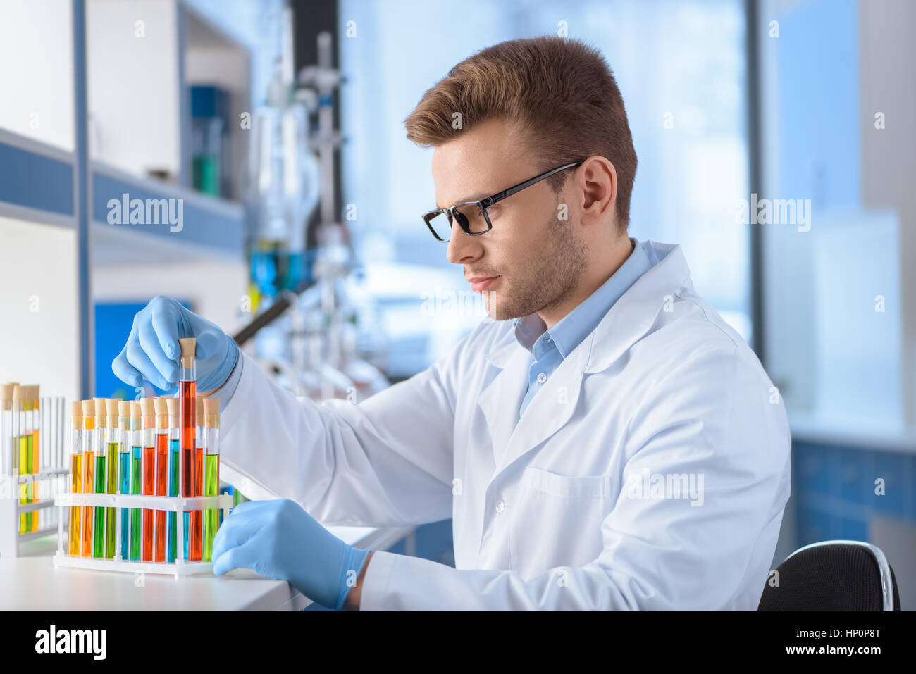 scientist in eyeglasses working with test tubes in lab Stock Photo - Alamy