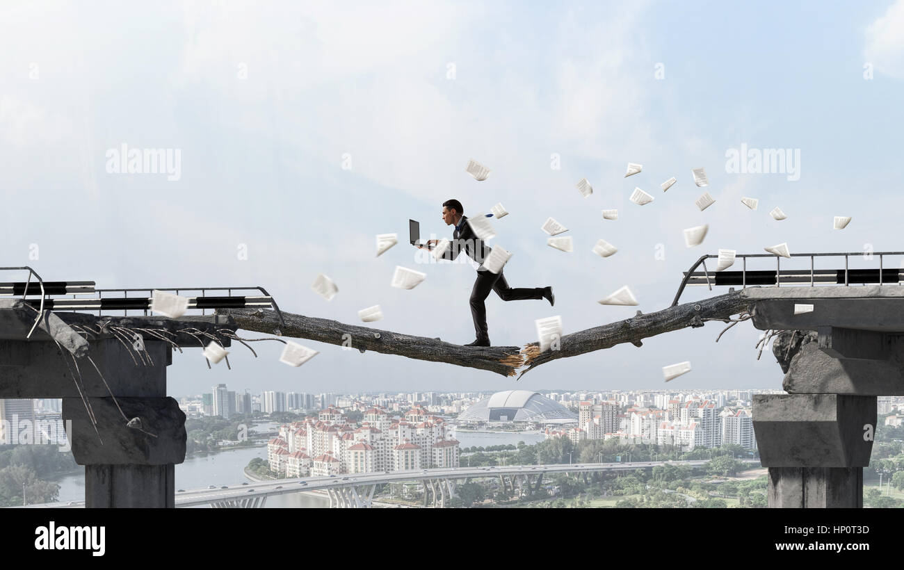 Businessman jumping over a gap in bridge as symbol of problem ...