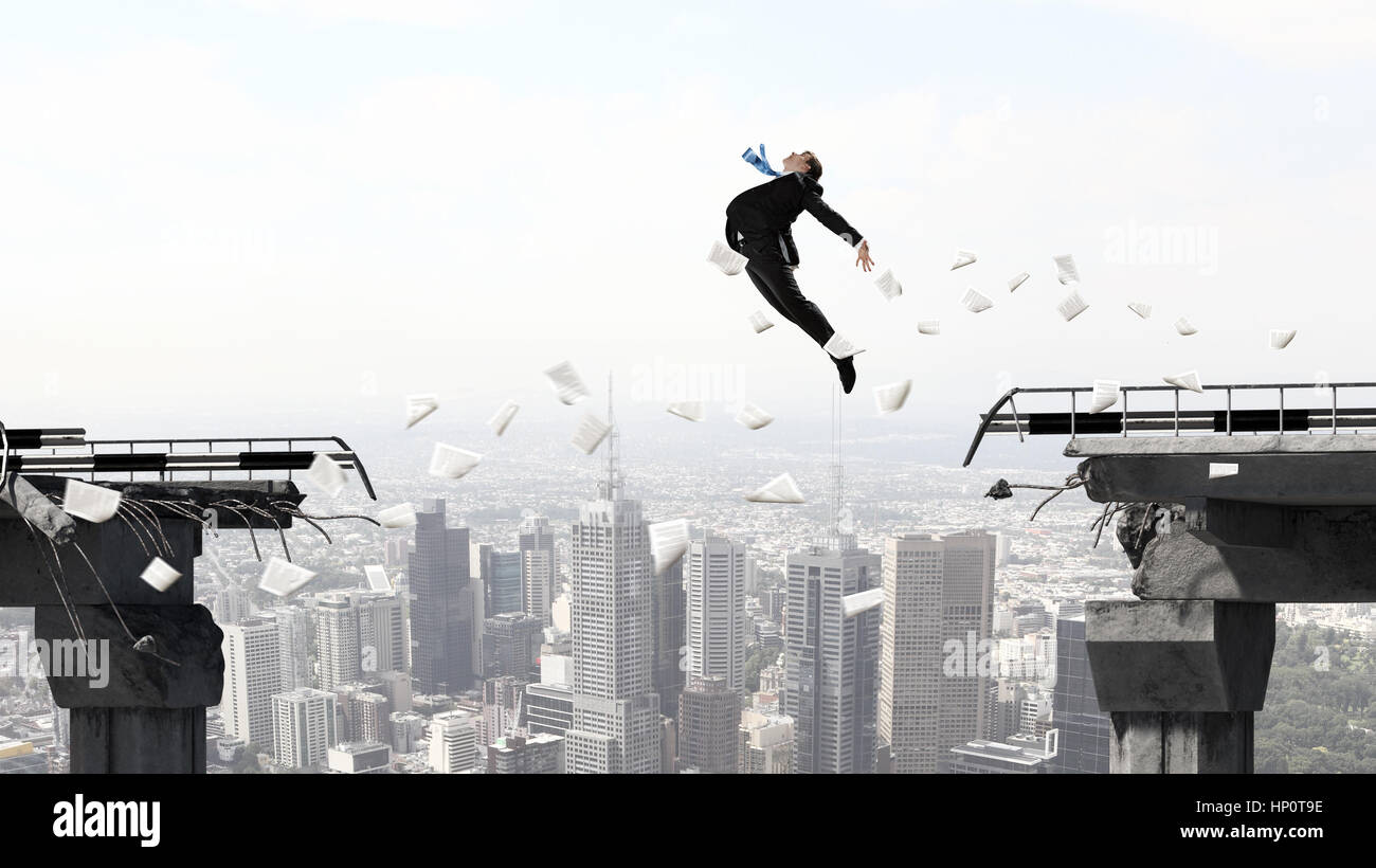 Businessman jumping over a gap in bridge as symbol of problem ...