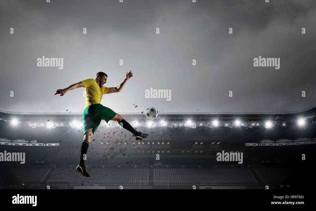 Soccer player with ball in action at stadium. Mixed media Stock Photo ...