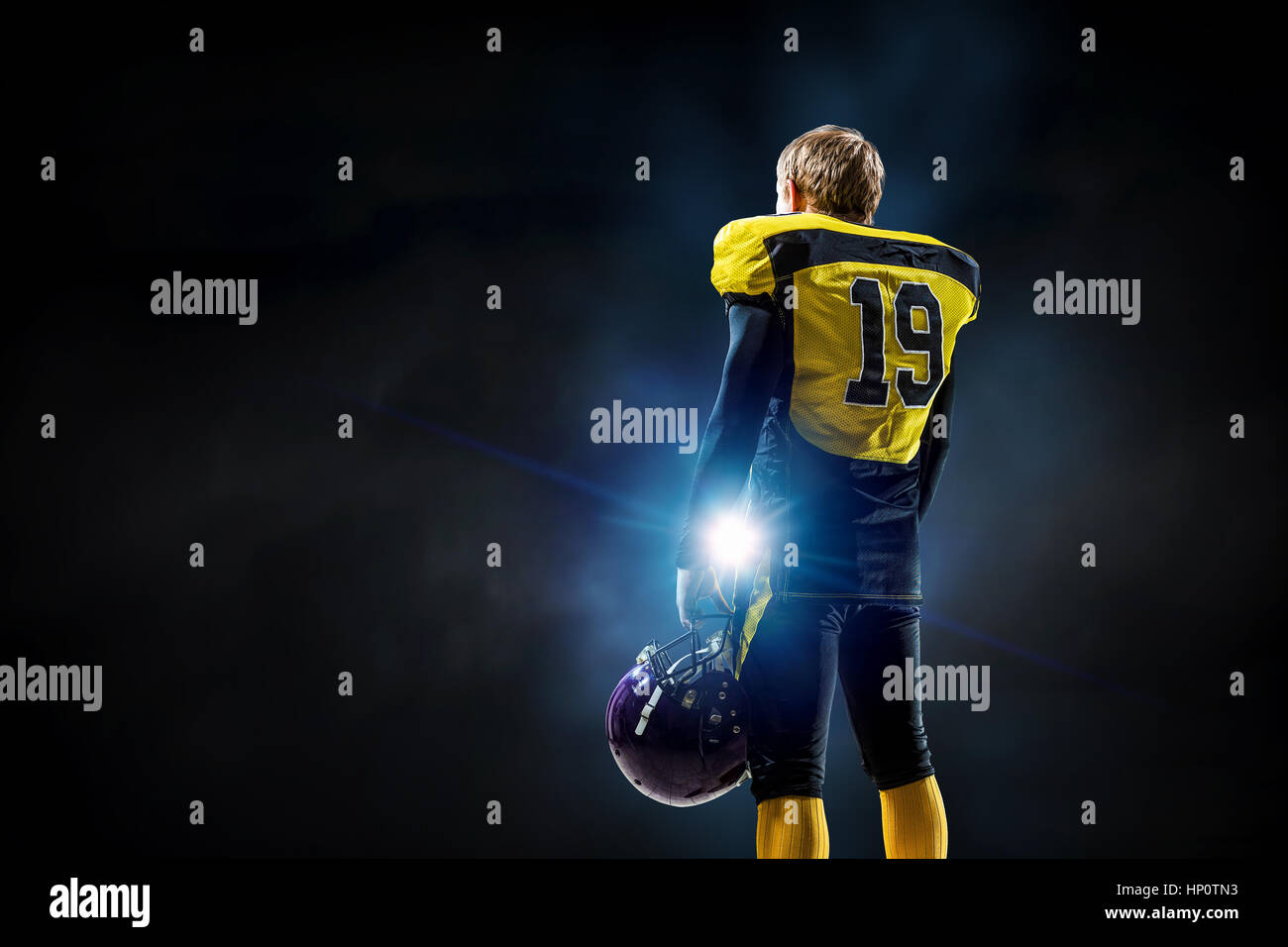Confident American football player against night sky background Stock ...
