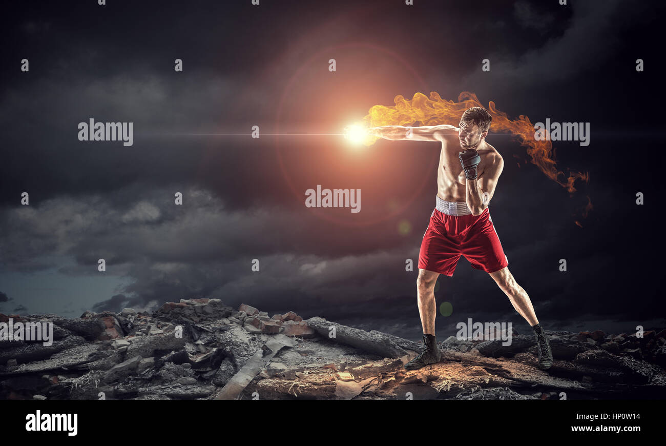 Strong fighter in shorts against dark sky background. Mixed media Stock ...