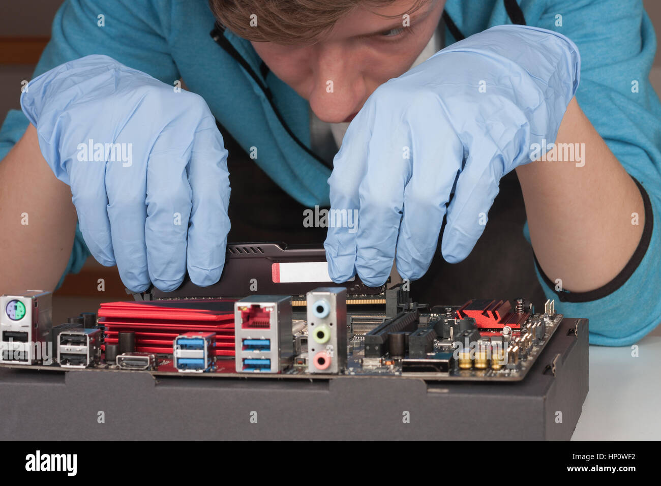 Young man with gloves installing Ram DDR4 memory module in slot on ...
