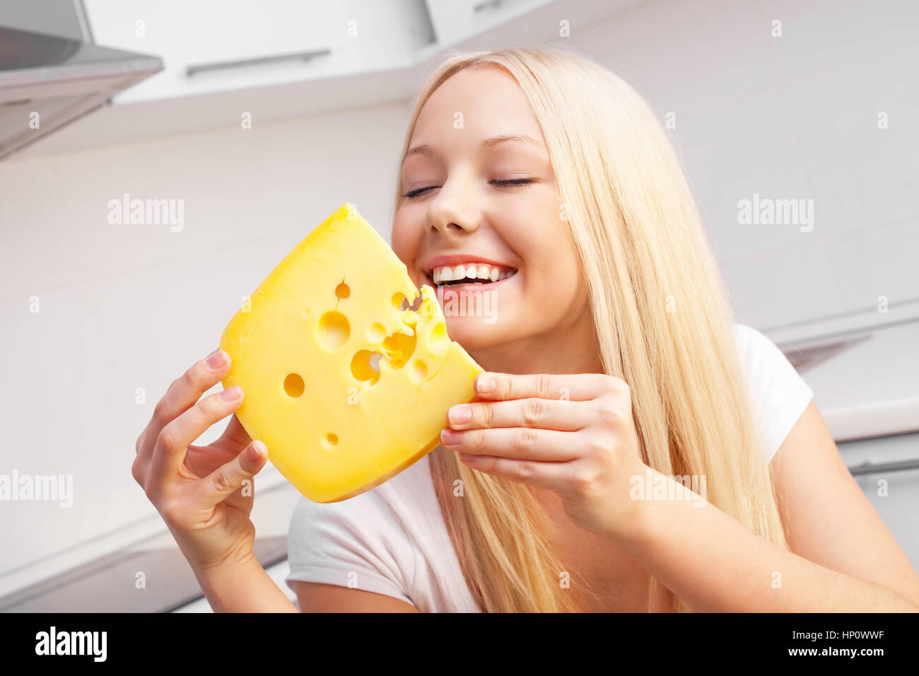 happy young beautiful woman eating cheese at home Stock Photo - Alamy
