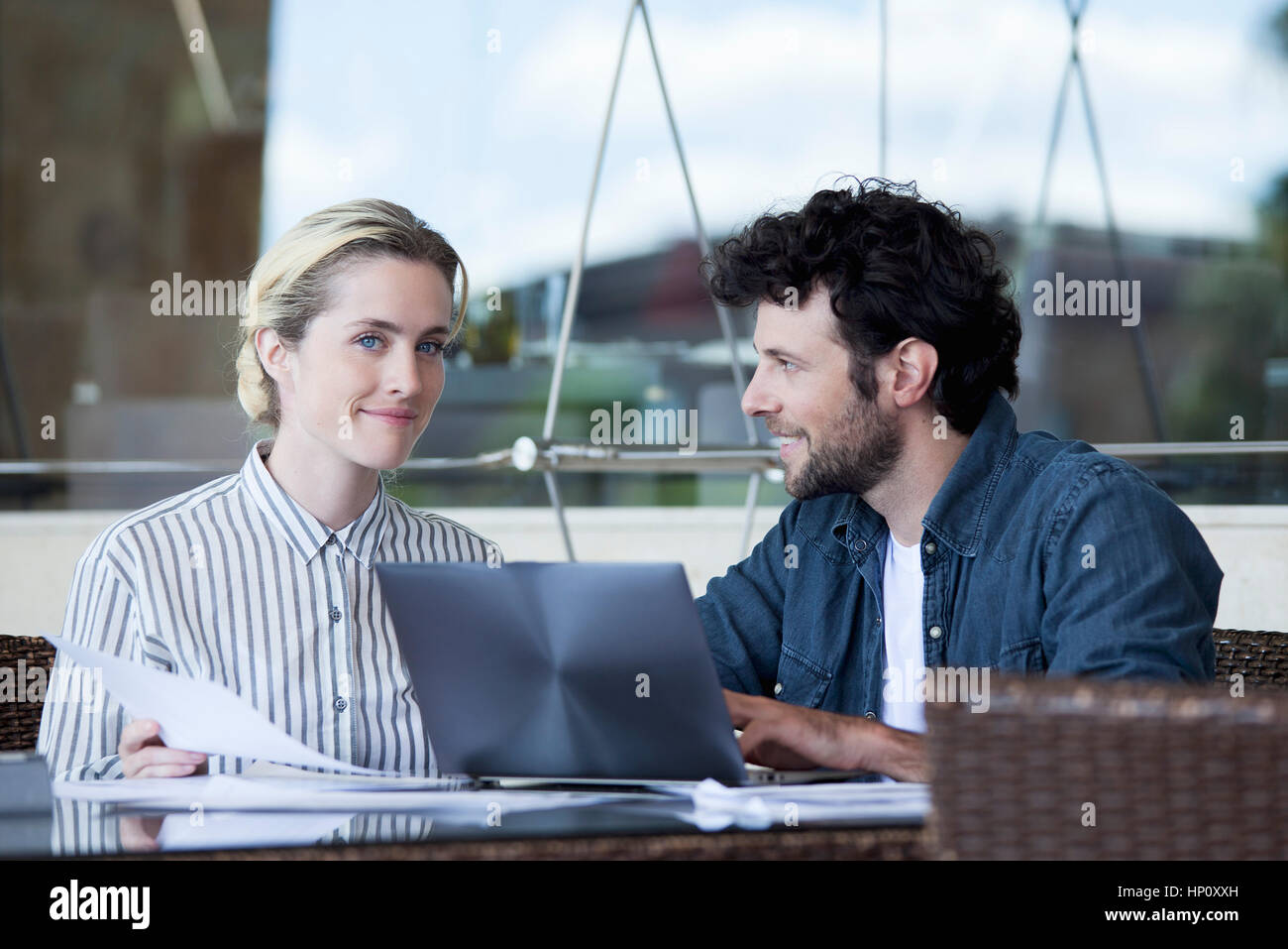 Colleagues using laptop computer together Stock Photo - Alamy
