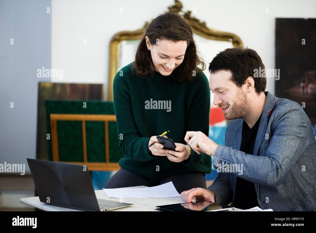 Woman sharing content of smartphone with colleague Stock Photo - Alamy