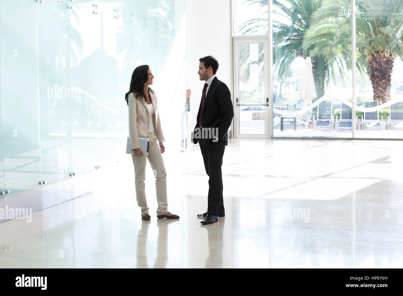 Business associates talking in office corridor Stock Photo - Alamy