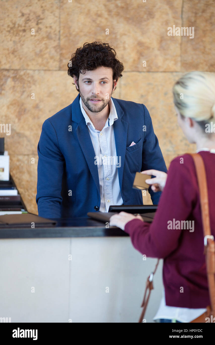 Hotel receptionist assisting guest Stock Photo - Alamy