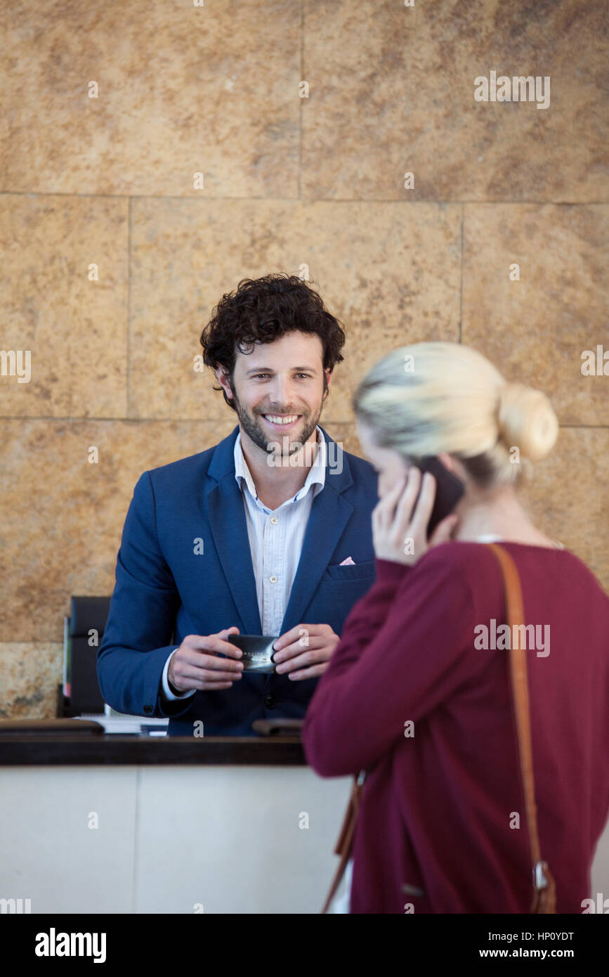 Friendly receptionist waiting to assist customer on cell phone Stock ...