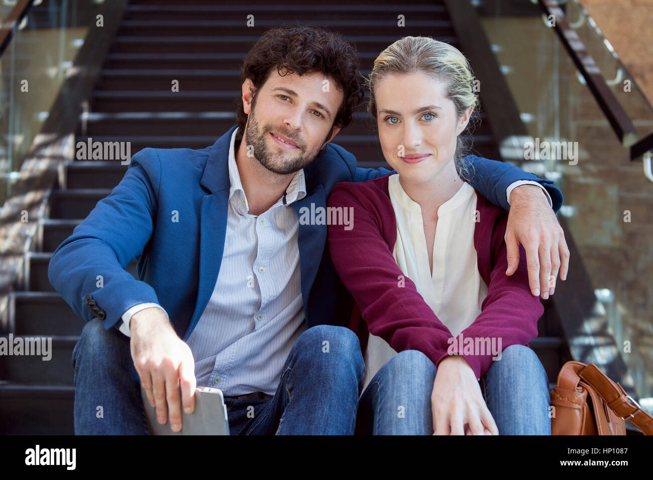 Couple sitting together on stairs, portrait Stock Photo - Alamy