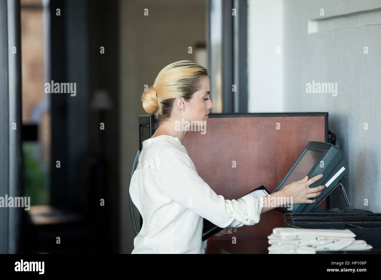 Waitress using computer in restaurant Stock Photo - Alamy