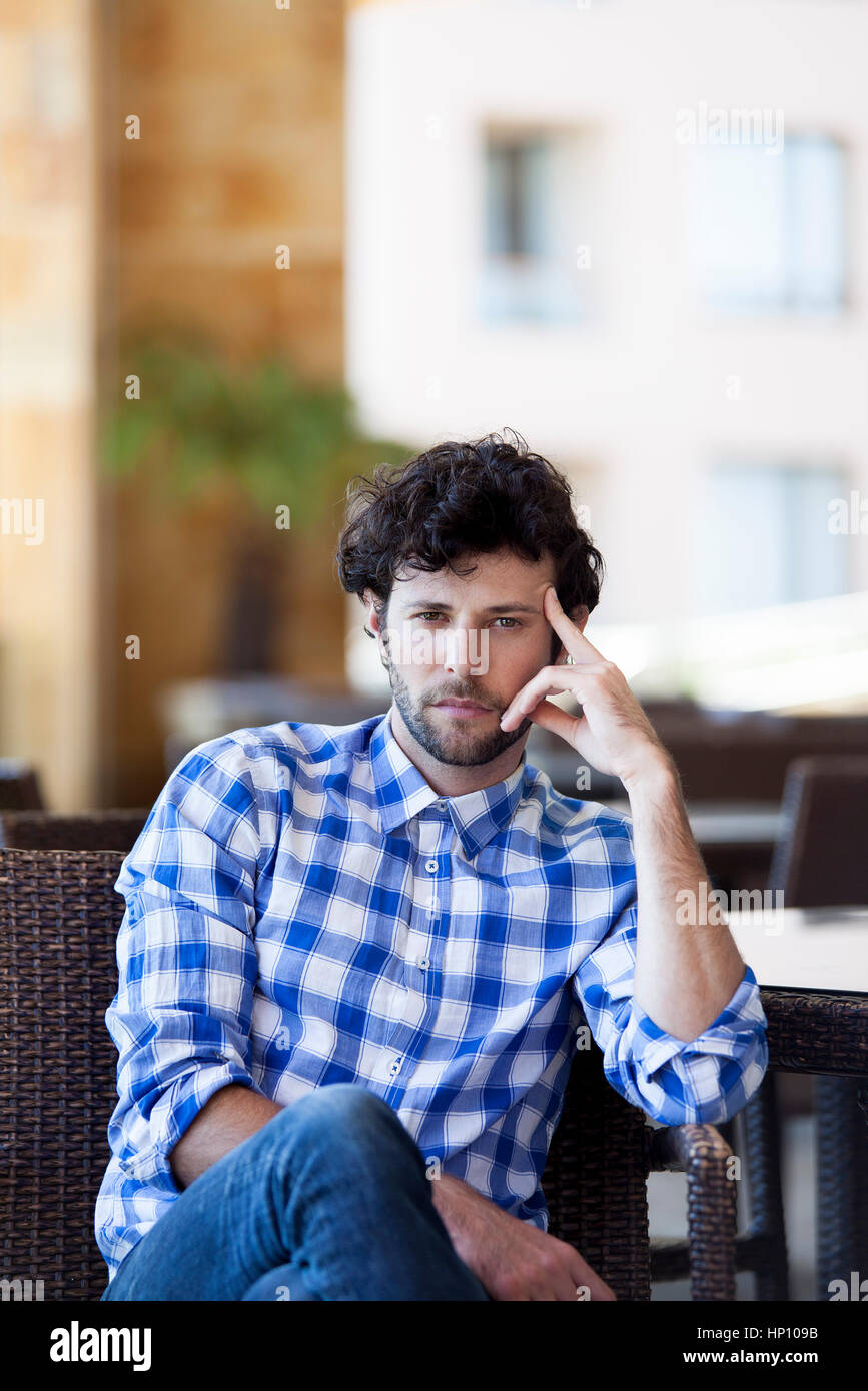 Man sitting with pensive expression on face, portrait Stock Photo - Alamy