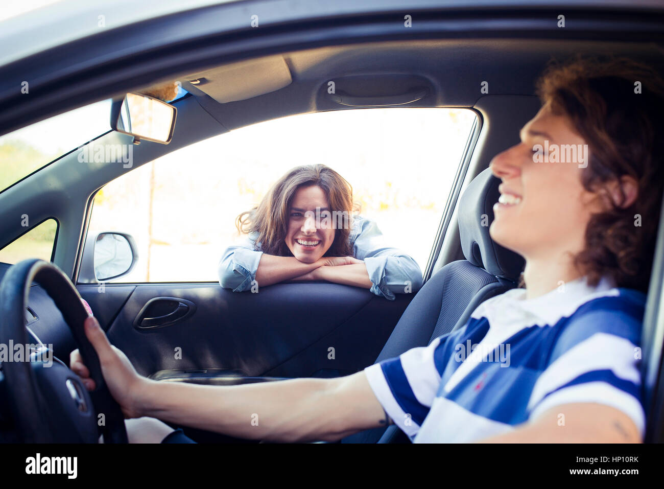 Woman looking into car window while man sitting in driver seat Stock ...