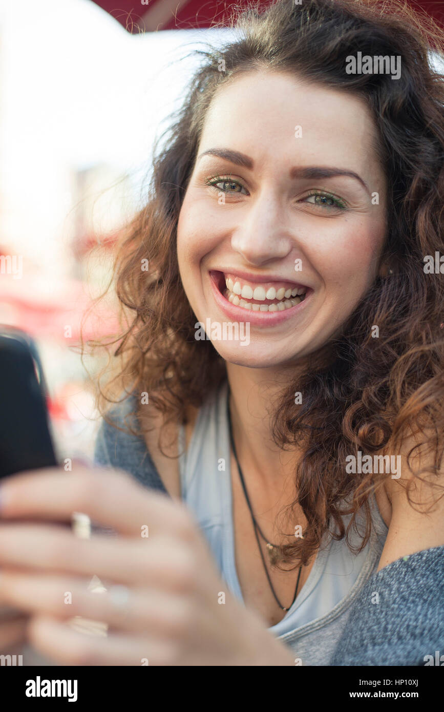 Young woman using smartphone, smiling, portrait Stock Photo - Alamy