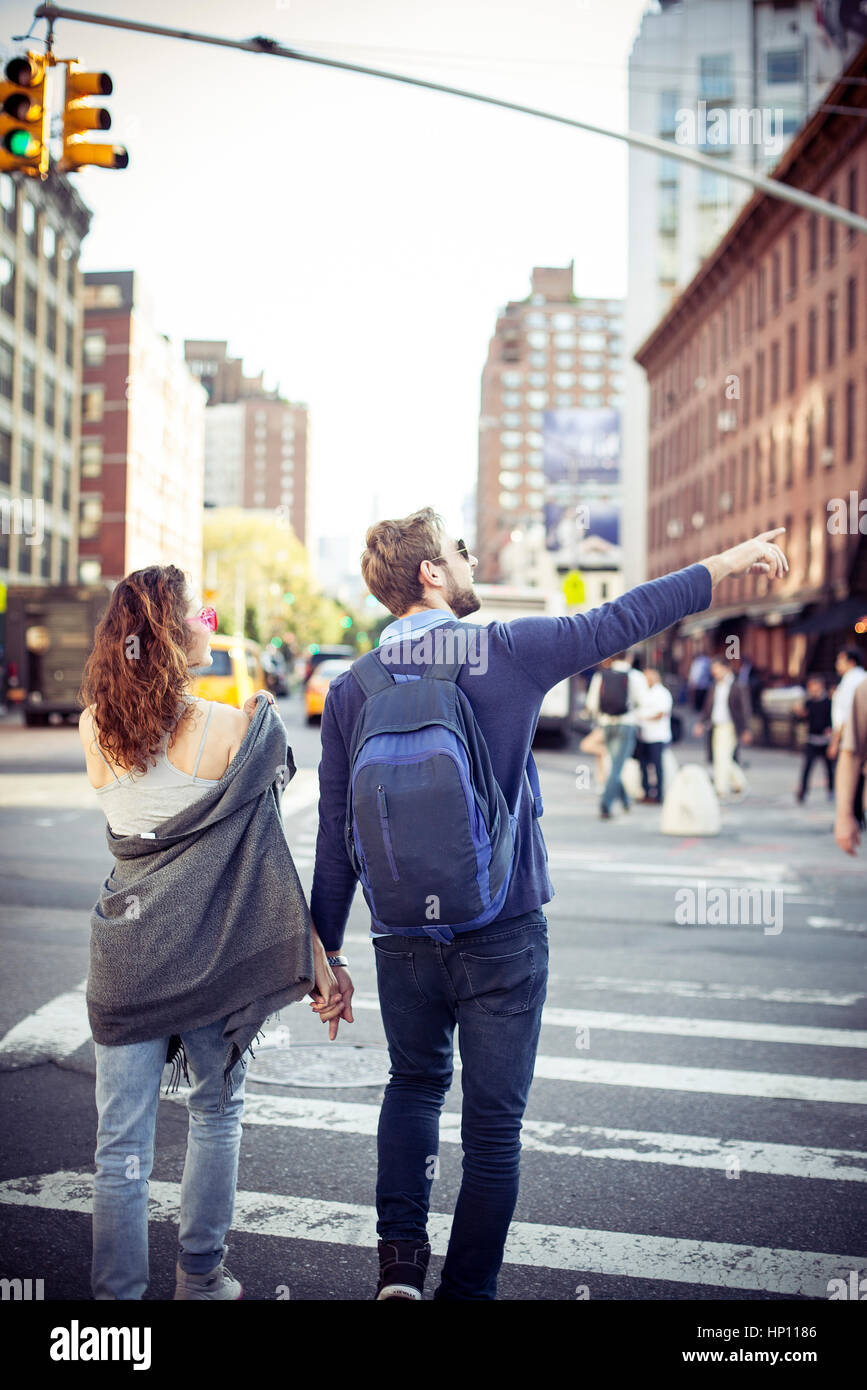 Couple crossing city street, rear view Stock Photo - Alamy