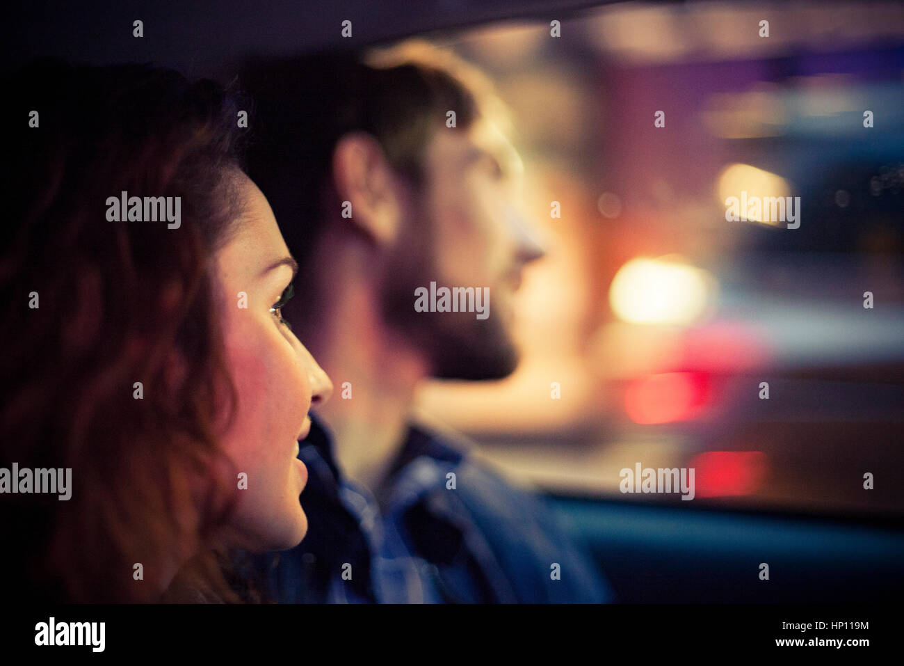 Couple looking out car window at night Stock Photo - Alamy