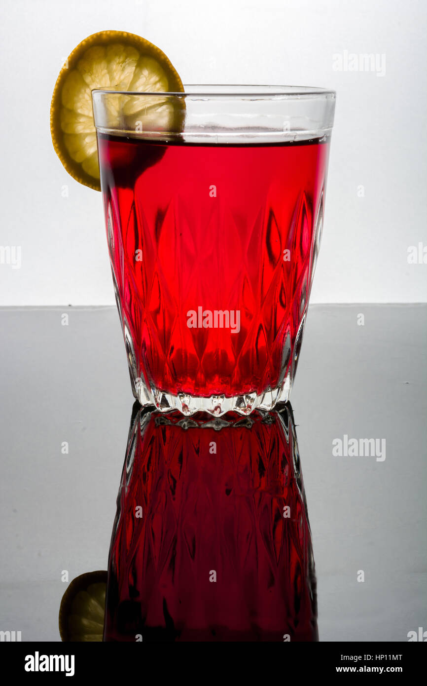 A glass with red drink on a light background Stock Photo - Alamy