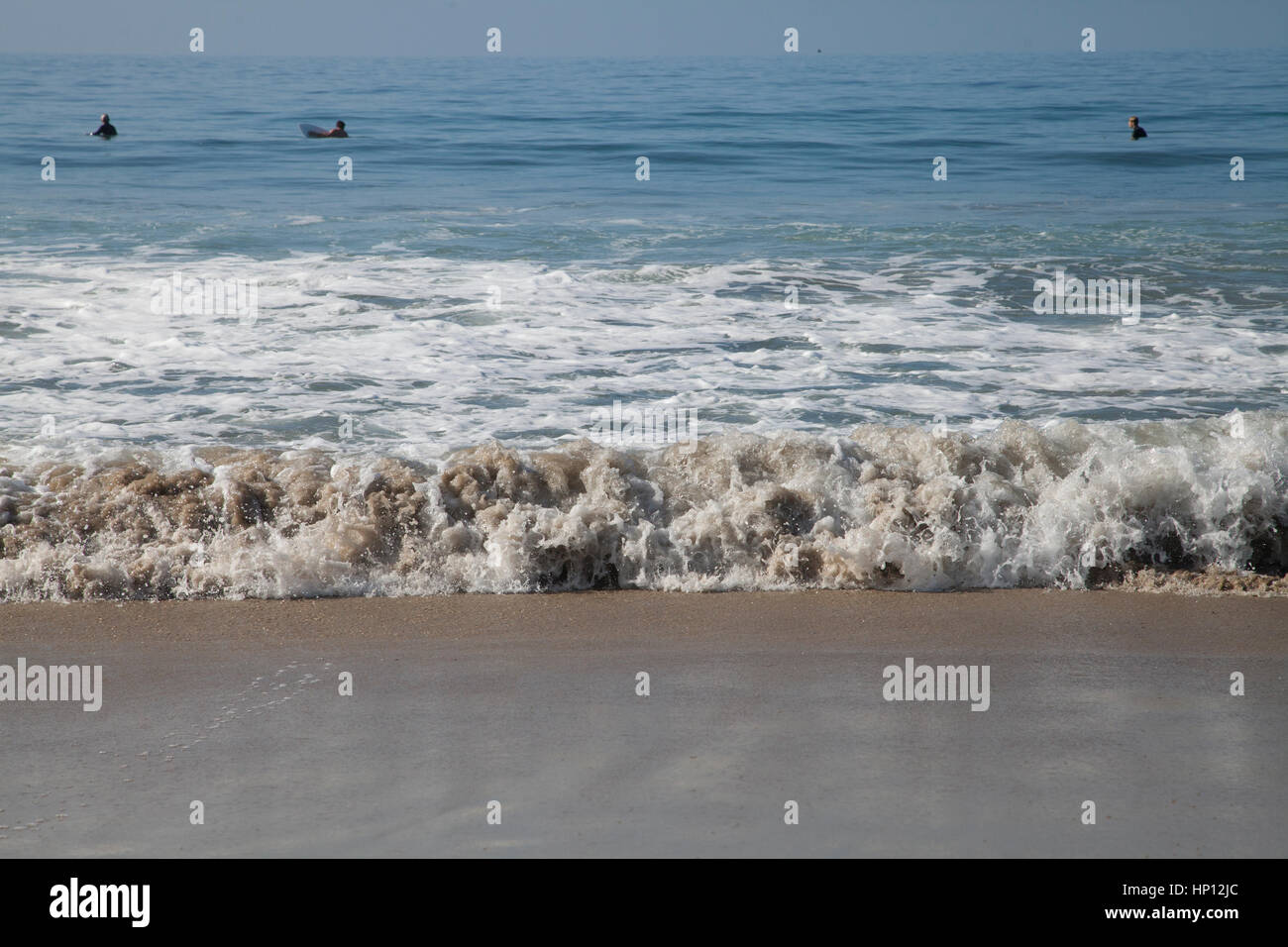 Heavy, foamy waves lapping at the ocean shore Stock Photo - Alamy