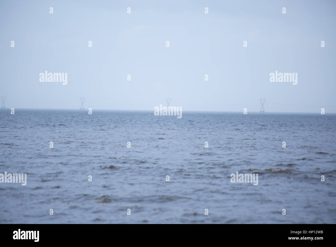 Electric pylons on the ocean horizon in the distance Stock Photo - Alamy