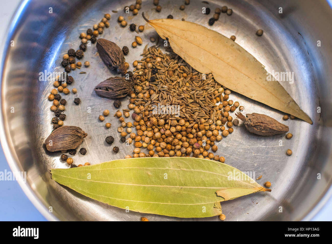 Roasting fresh whole spices in pan Stock Photo - Alamy