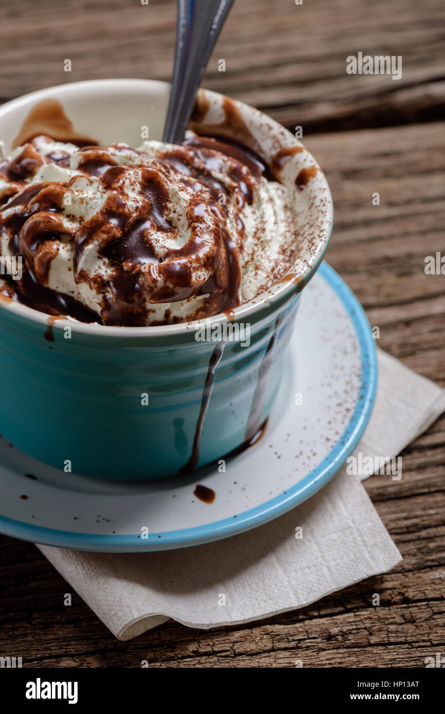 a cup of whipped cream with chocolate syrup on wooden table Stock Photo ...