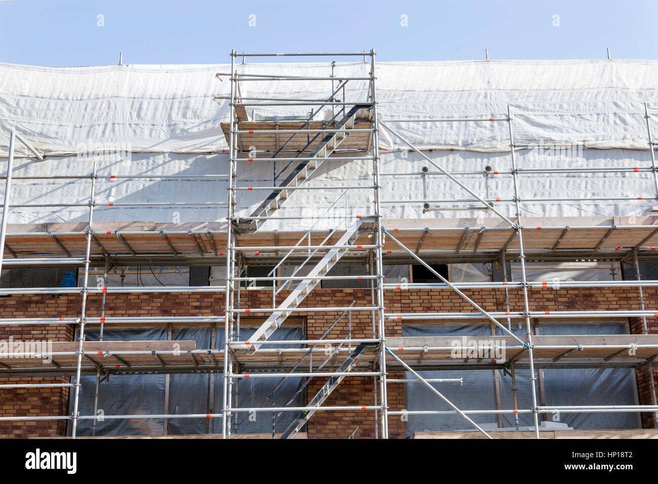 scaffolding with stairs under blue sky on new housing facility in the ...