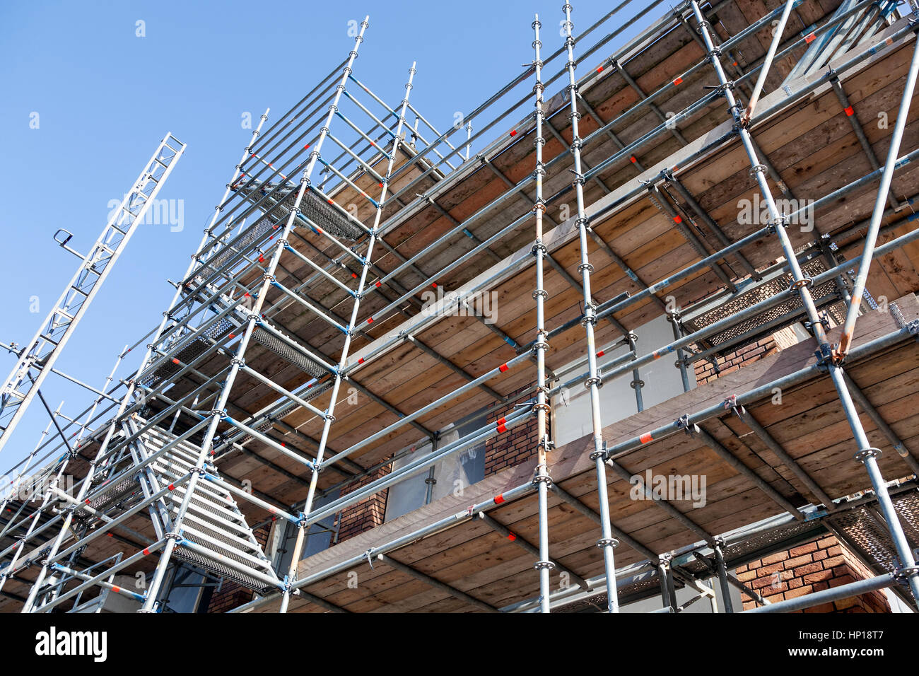 scaffolding with stairs under blue sky on new housing facility in the ...
