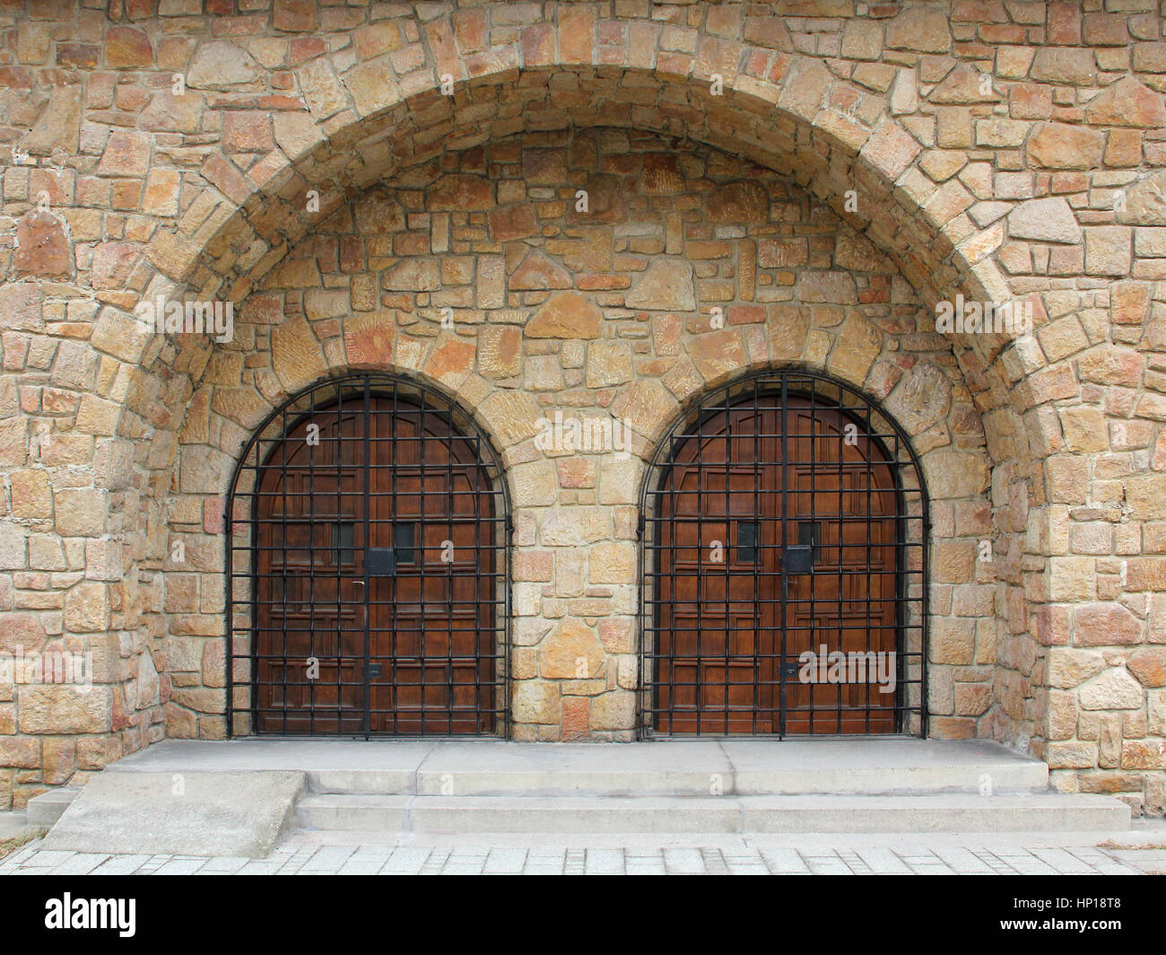 Double-arched stone temple entrance closed iron bars Stock Photo - Alamy