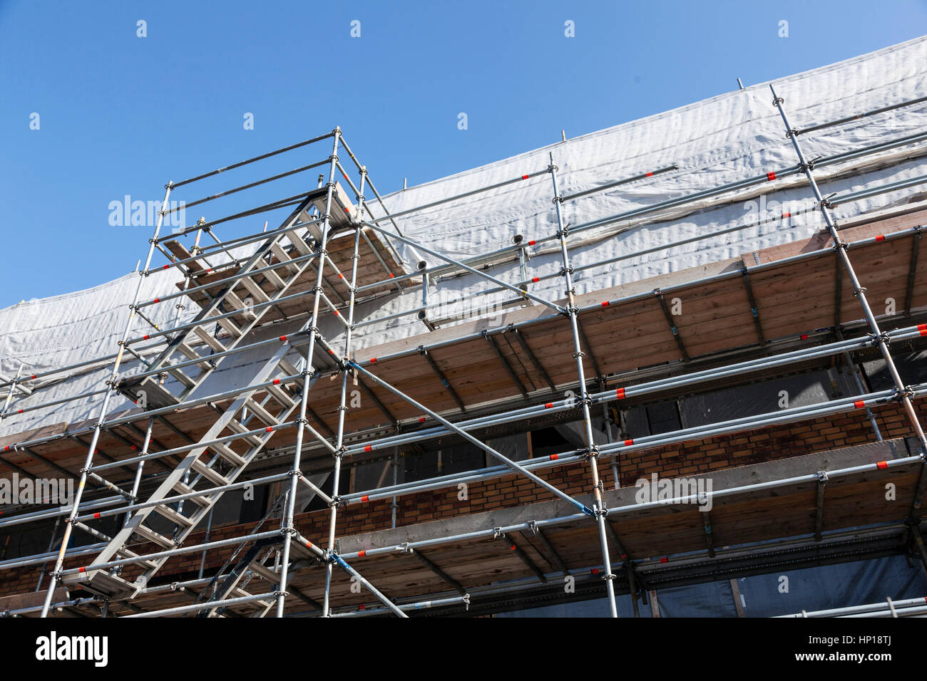 scaffolding with stairs under blue sky on new housing facility in the ...