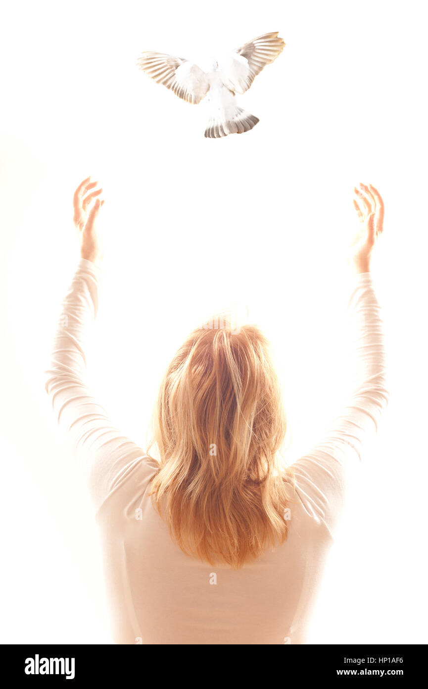 blond woman with open arms and a pigeon flying away Stock Photo - Alamy