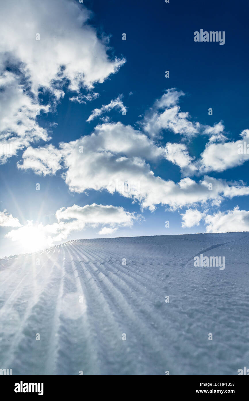 Winter landscape with unbroken ski slope, sun and blue sky Stock Photo ...